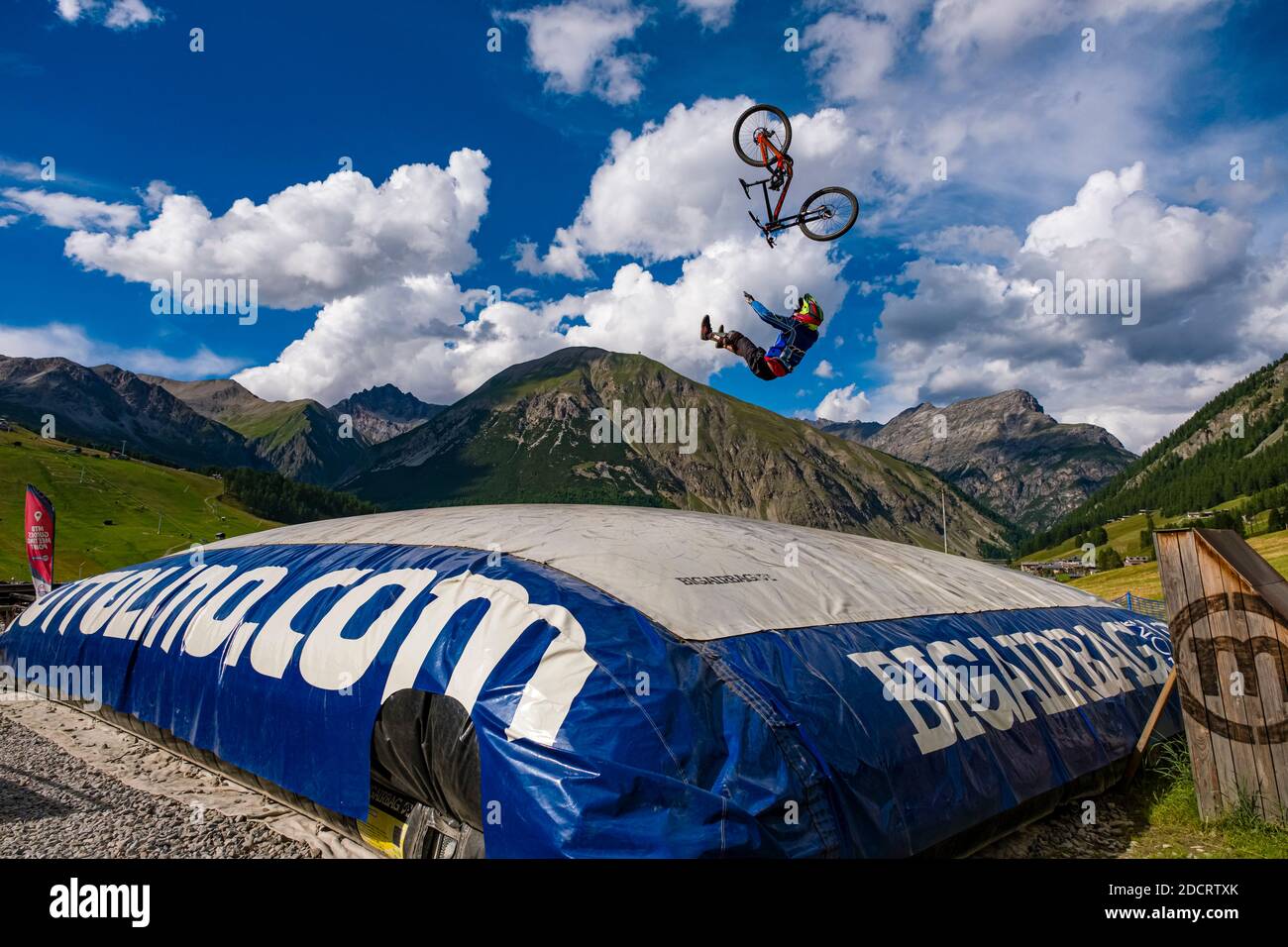 A downhill cyclist is practising a difficult jump with the safety of ...
