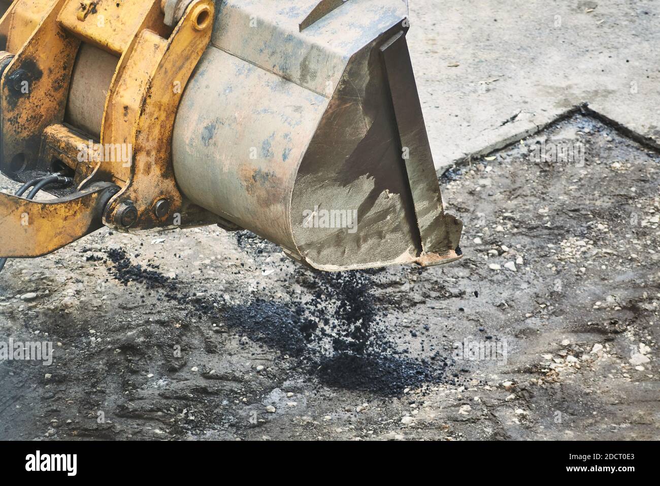 tractor unloading hot asphalt into the pit. road repair Stock Photo - Alamy