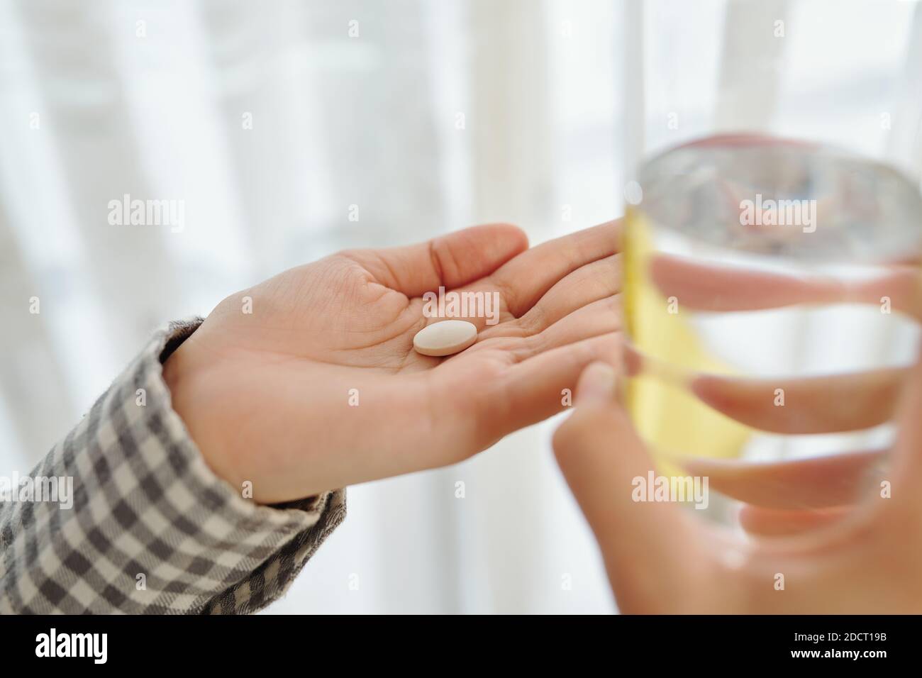 Person taking painkiller Stock Photo - Alamy