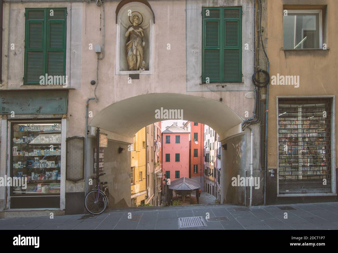 Colorful apartment buildings behind an arch surmounted by a sacred ...