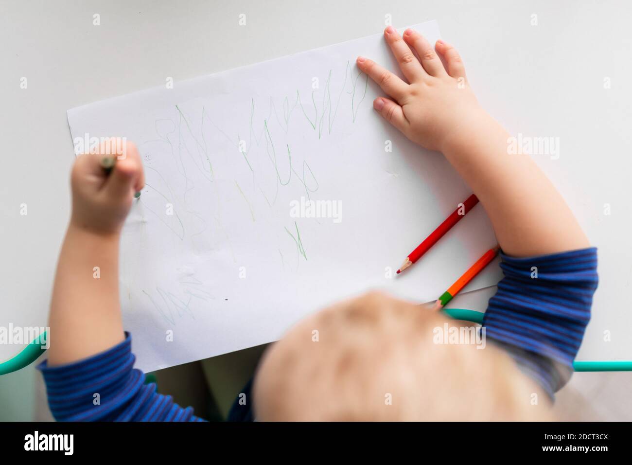 Left handed baby boy drawing a picture with colored pencils Stock Photo ...