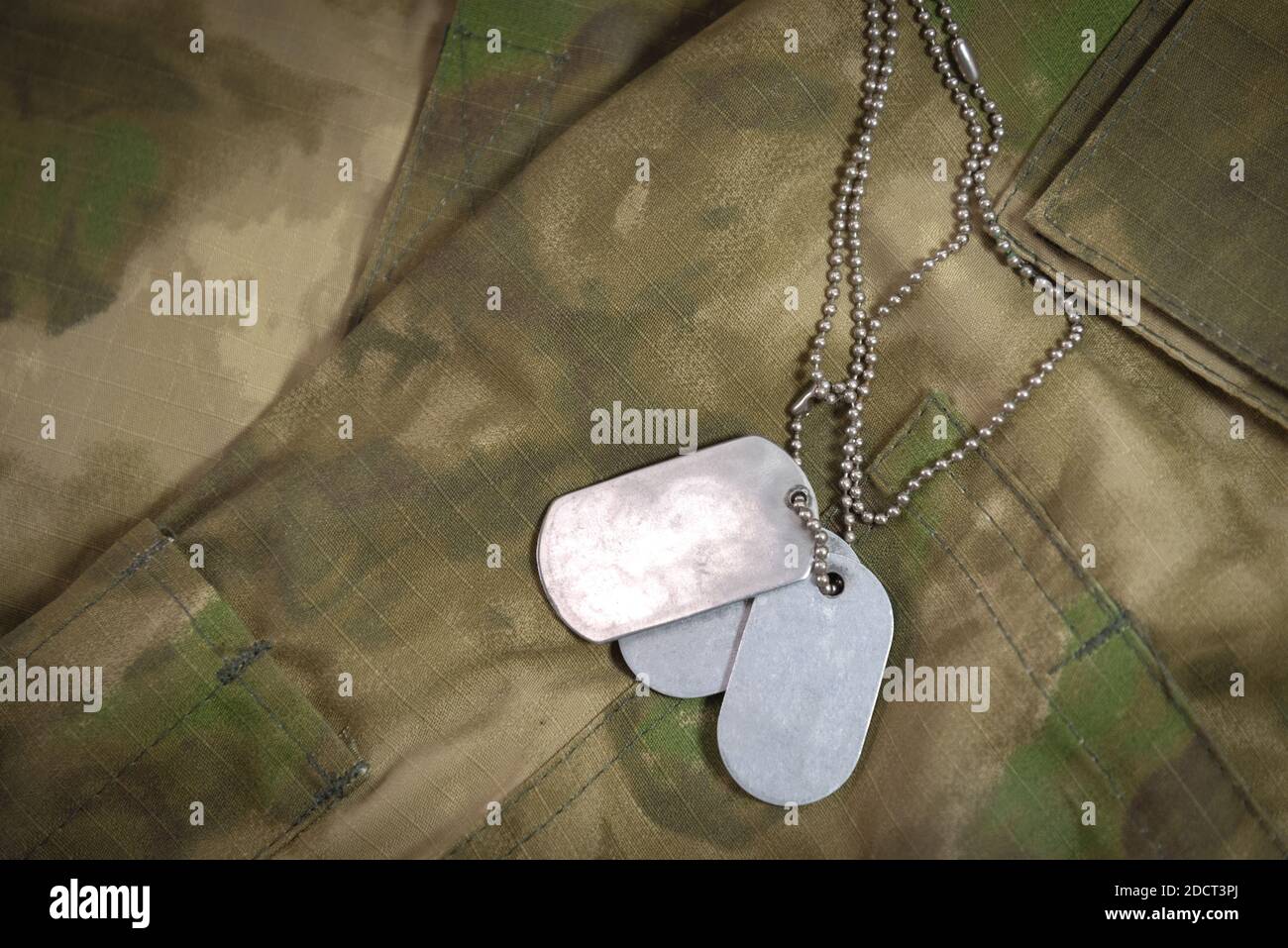 a soldier's badge with a chain lie on a military camouflage jacket ...