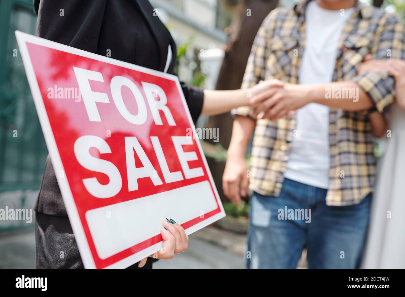 Estate agent greeting customer Stock Photo - Alamy