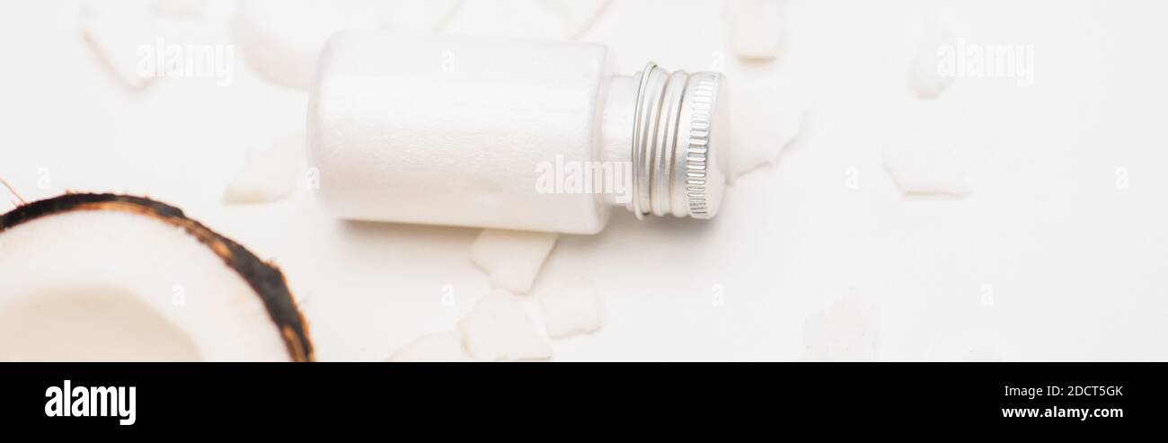 bottle of nourishing homemade lotion near coconut half and flakes on ...