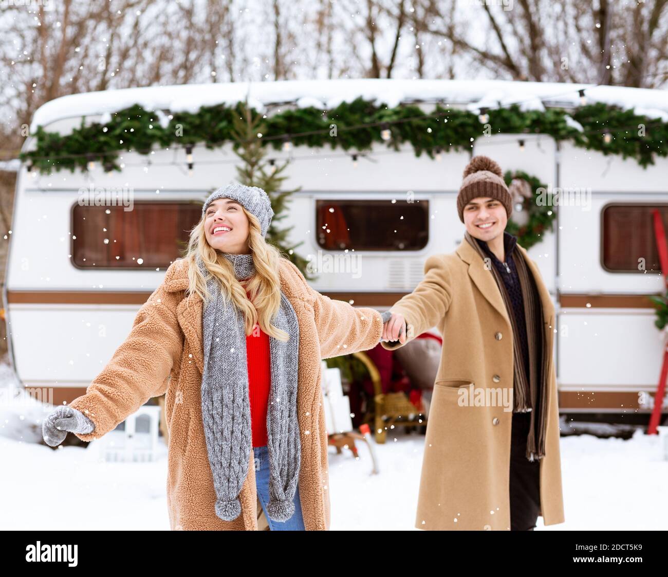 Romantic couple camping at winter with campervan, enjoying snow and ...