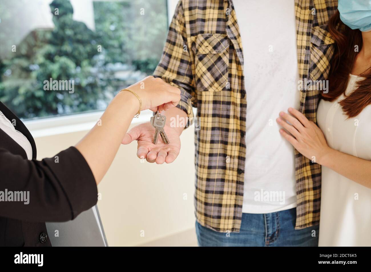 Giving house keys to young couple Stock Photo - Alamy