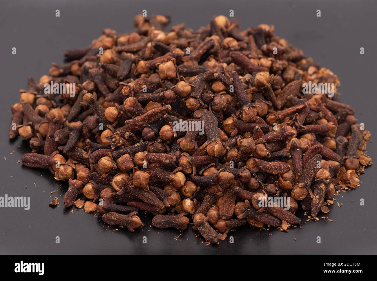 A pile of cloves close up isolated on a black background Stock Photo ...