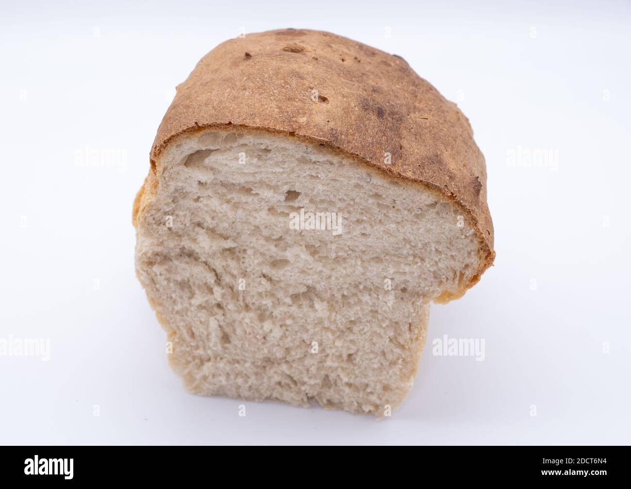 A plain white loaf cut in half isolated against a white background ...