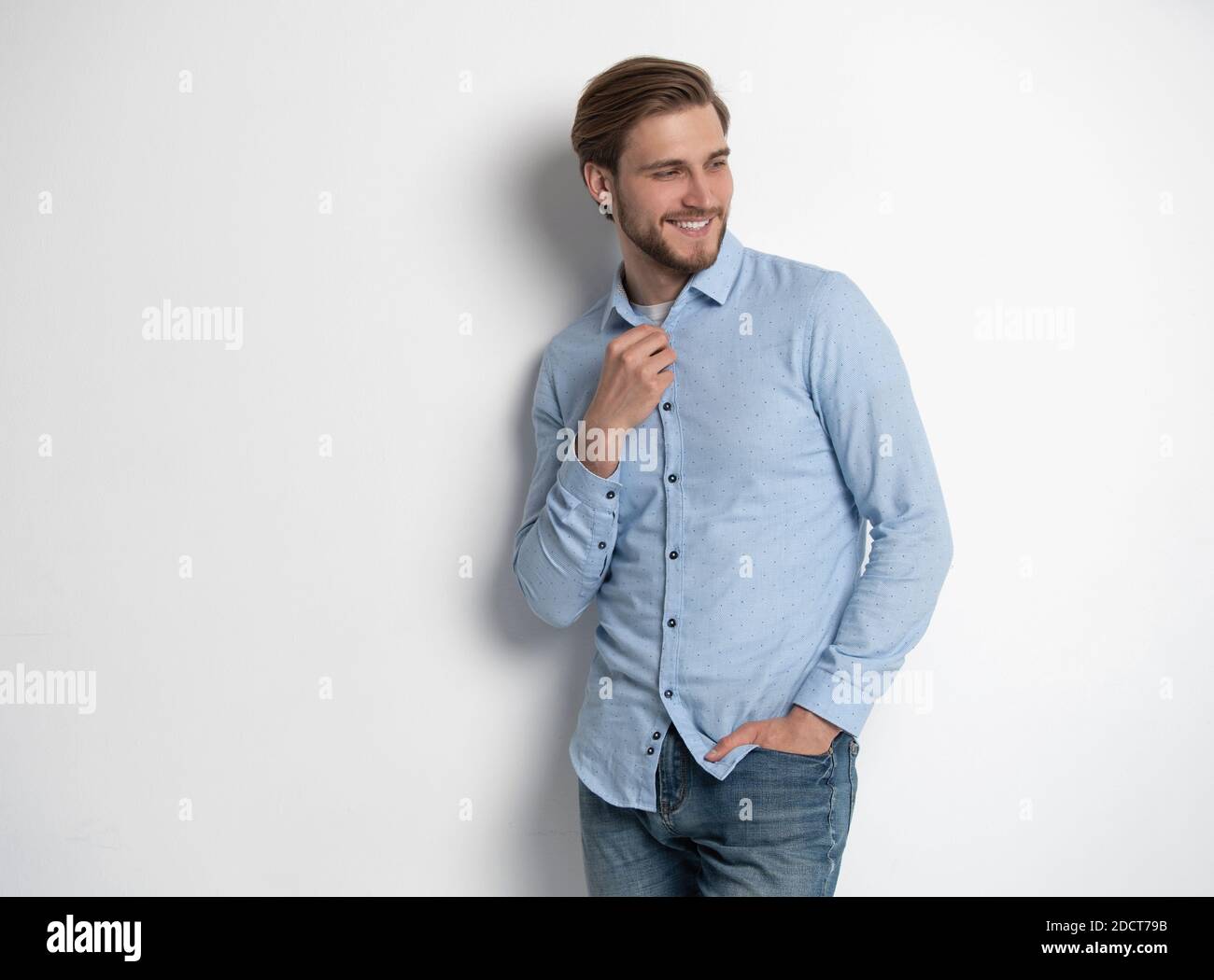 Portrait of a smart young man standing against white background Stock ...