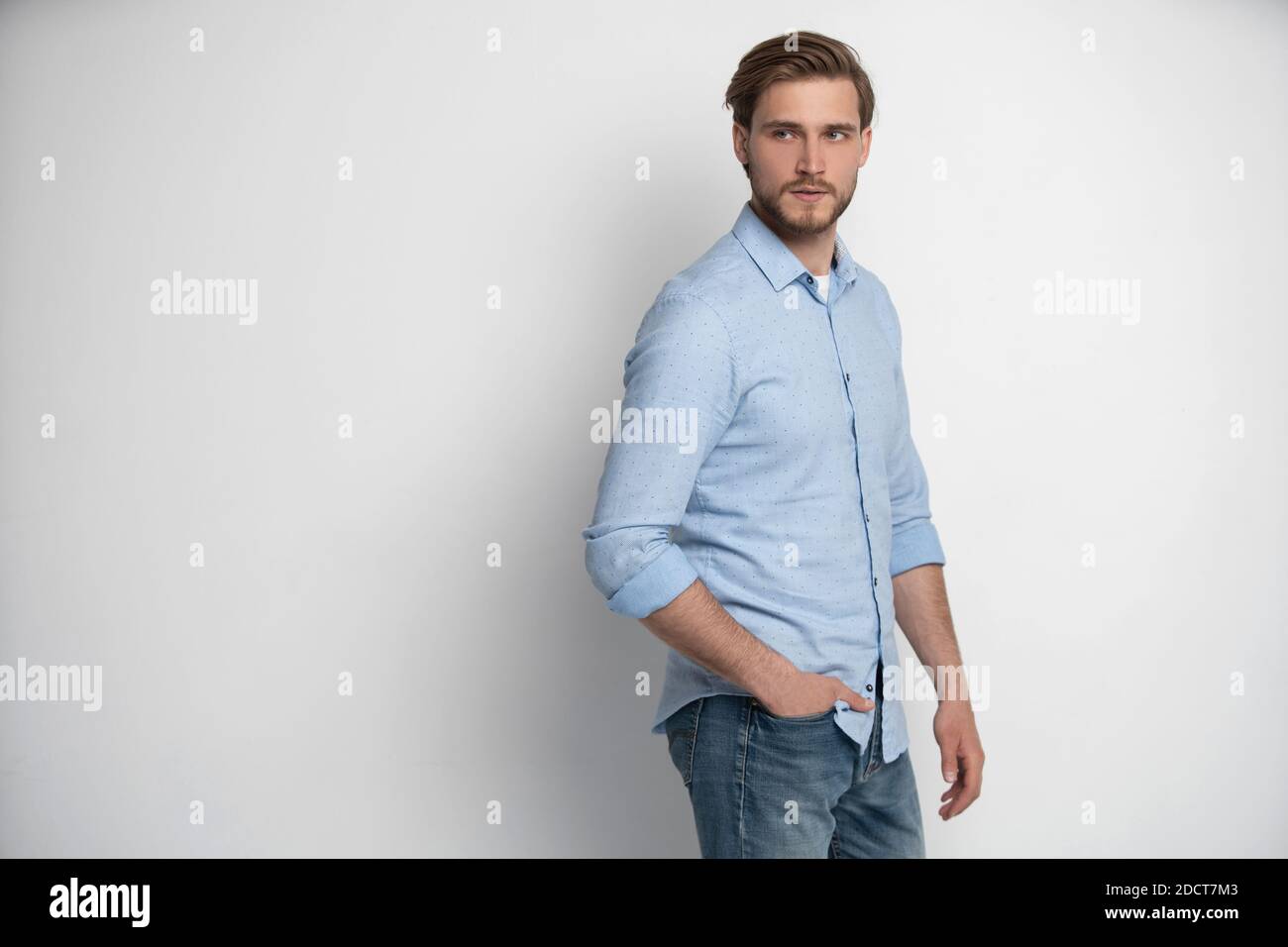 Portrait of a smart young man standing against white background Stock ...