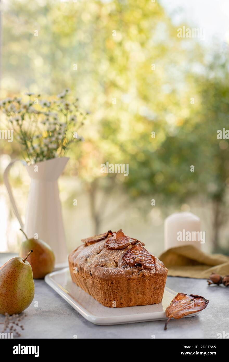muffin cake with pears, nuts on a window background. Light background ...