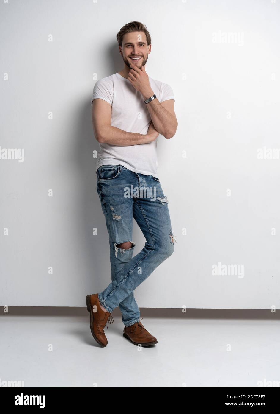 Full length studio portrait of casual young man in jeans and shirt ...