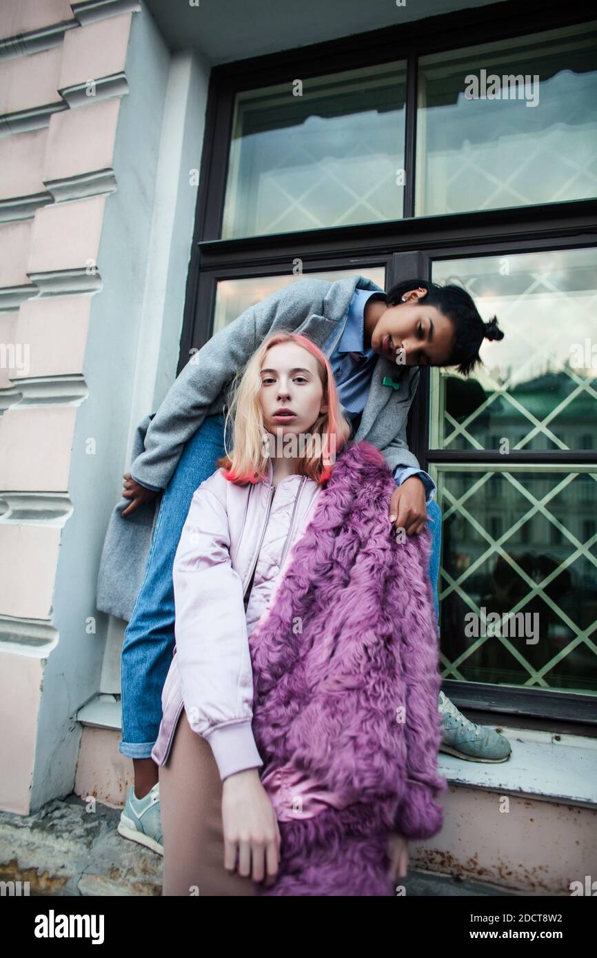 Two teenage girls infront of university building smiling, having fun ...