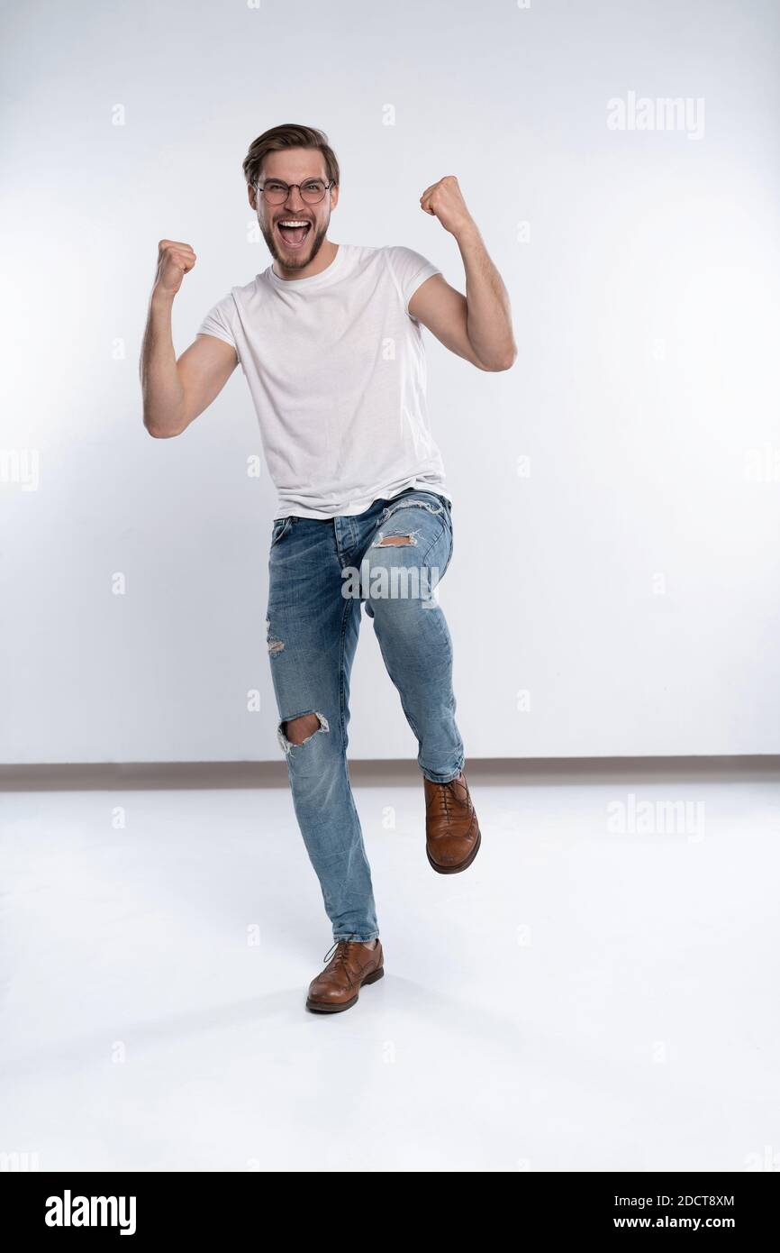 Happy winner. Happy young handsome man gesturing and keeping mouth open ...