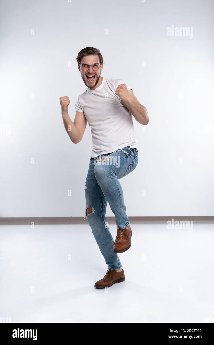 Happy winner. Happy young handsome man gesturing and keeping mouth open ...