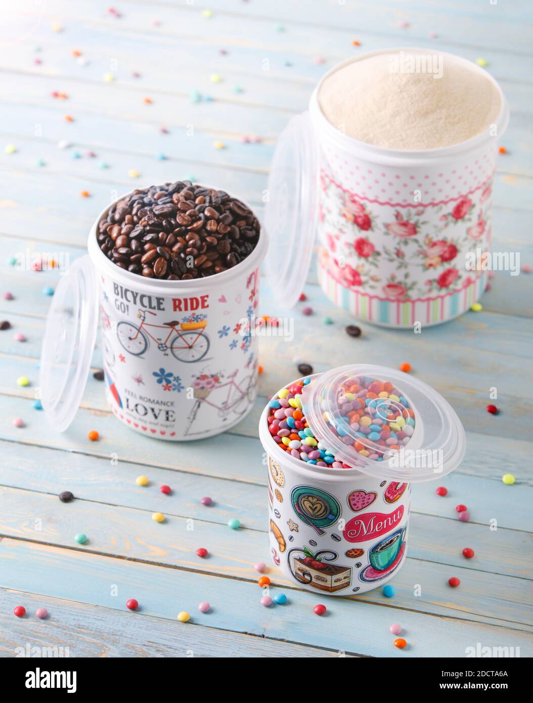 Smarties and coffee inside beautiful plastic containers on a wooden ...