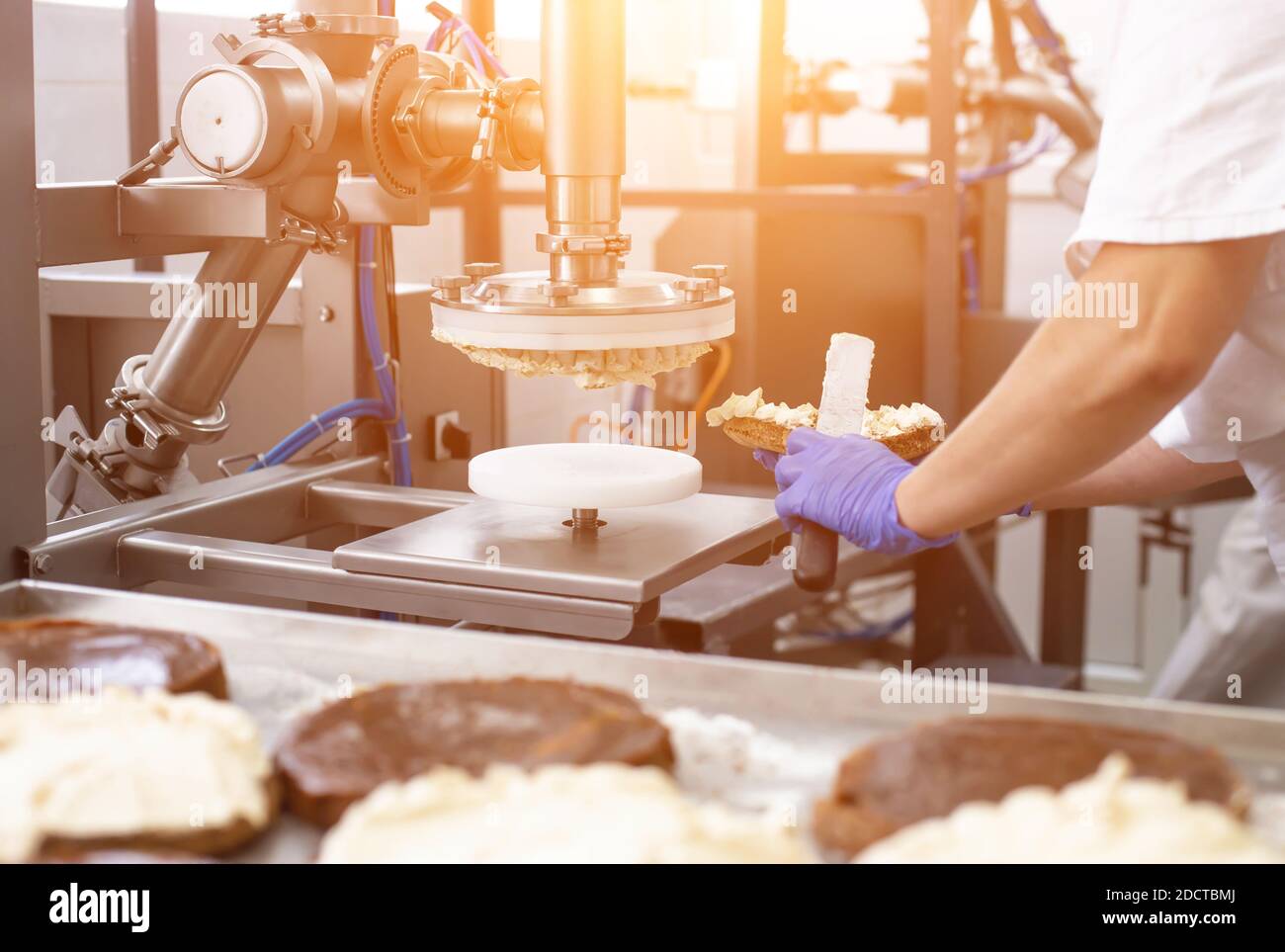 The pastry chef makes cake using modern equipment for the production of ...