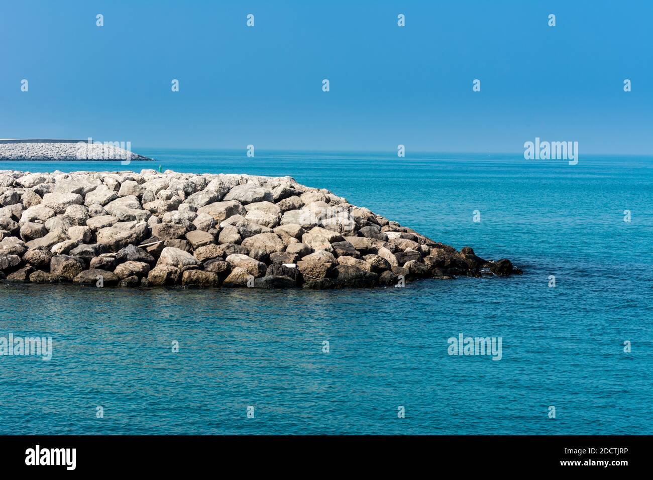 Blue sea and stone dam in the Persian Gulf in the Corniche park in the ...