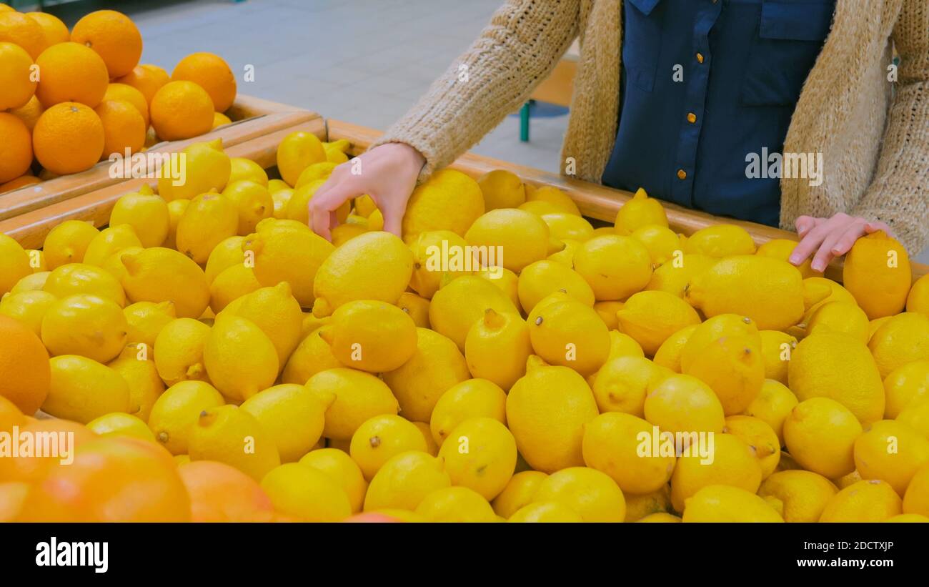 Woman buying fresh yellow lemons at grocery store Stock Photo - Alamy