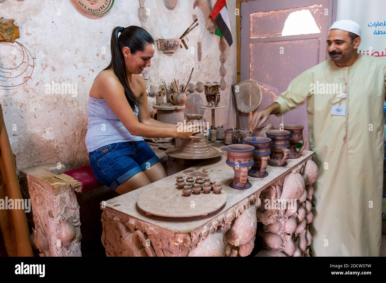 An Islamic potter teaching a female tourist making ceramic pots in ...