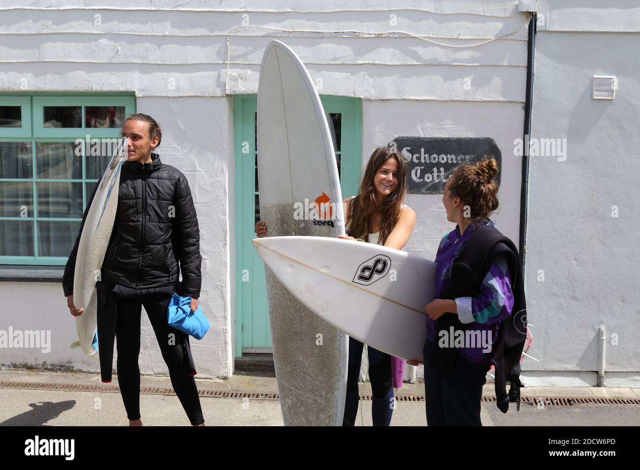 England, Cornwall, Newquay, Two blonde female surfers wearing wetsuits ...