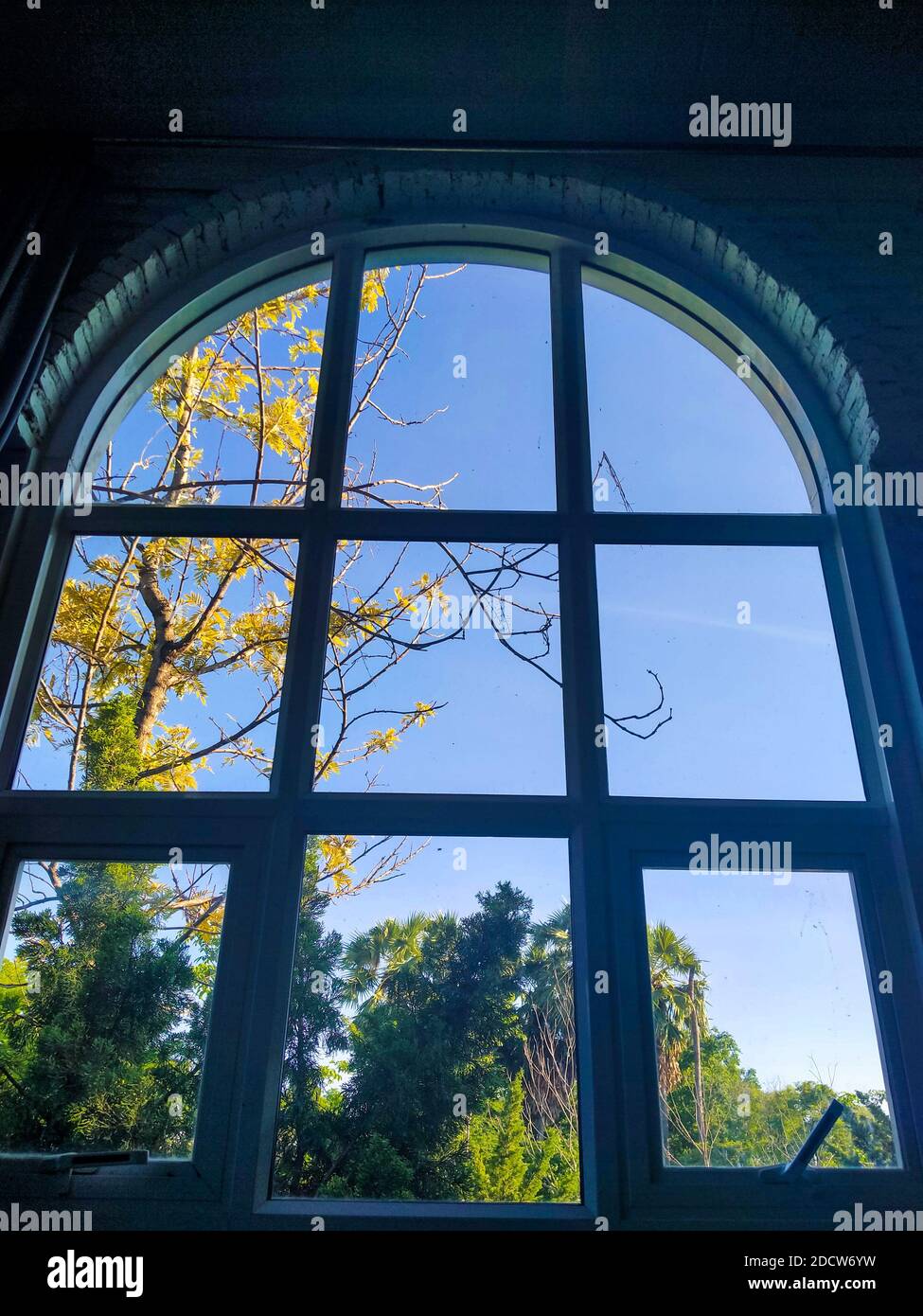 Arched window with view to autumnal landscape, bright sunshine. View ...