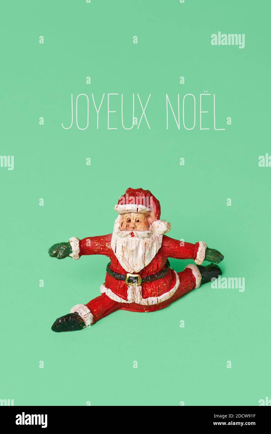 a figurine of santa claus jumping or in a split and the text merry ...