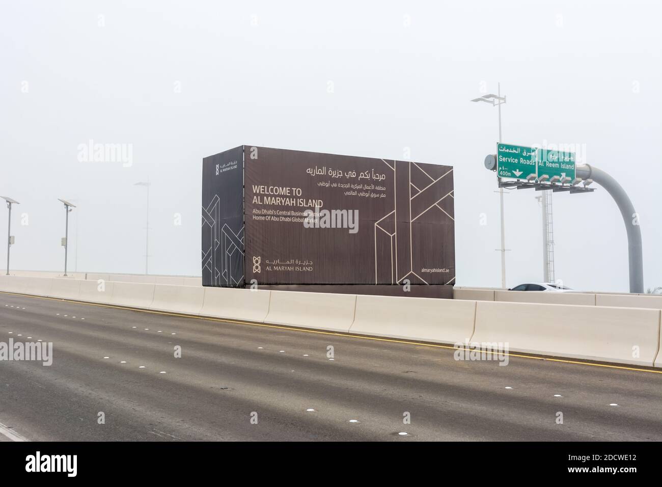 Giant road sign to Al Maryah Island under the thick fog at the street ...