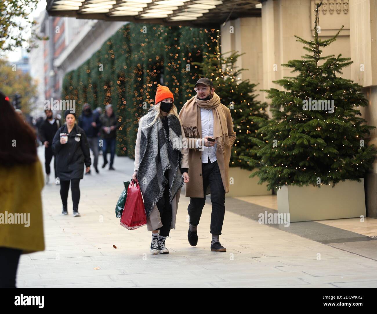 People walking past a Christmas tree outside a store on Oxford Street ...