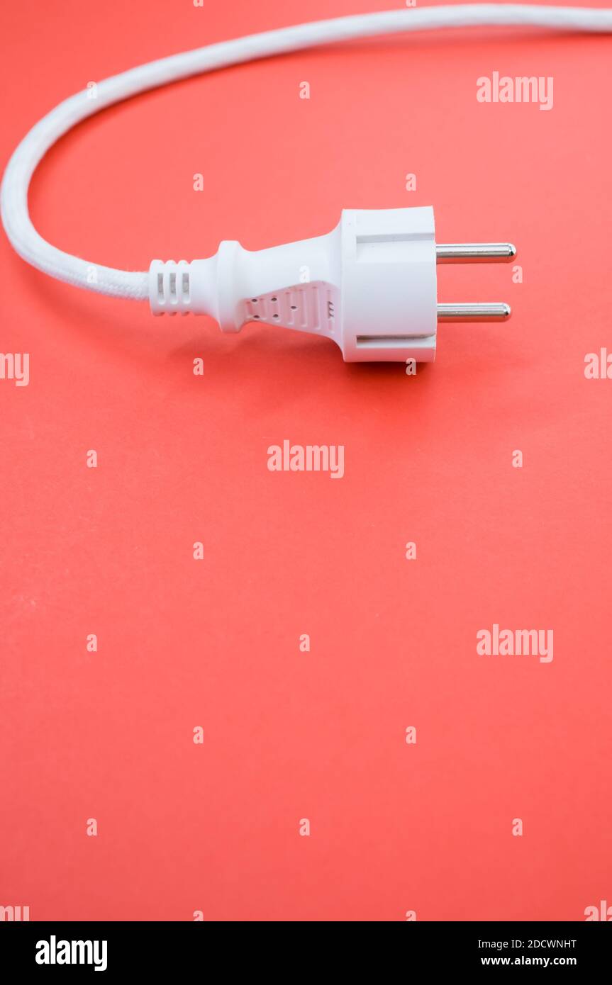 A vertical shot of an electrical wire and plug on a pink surface Stock ...
