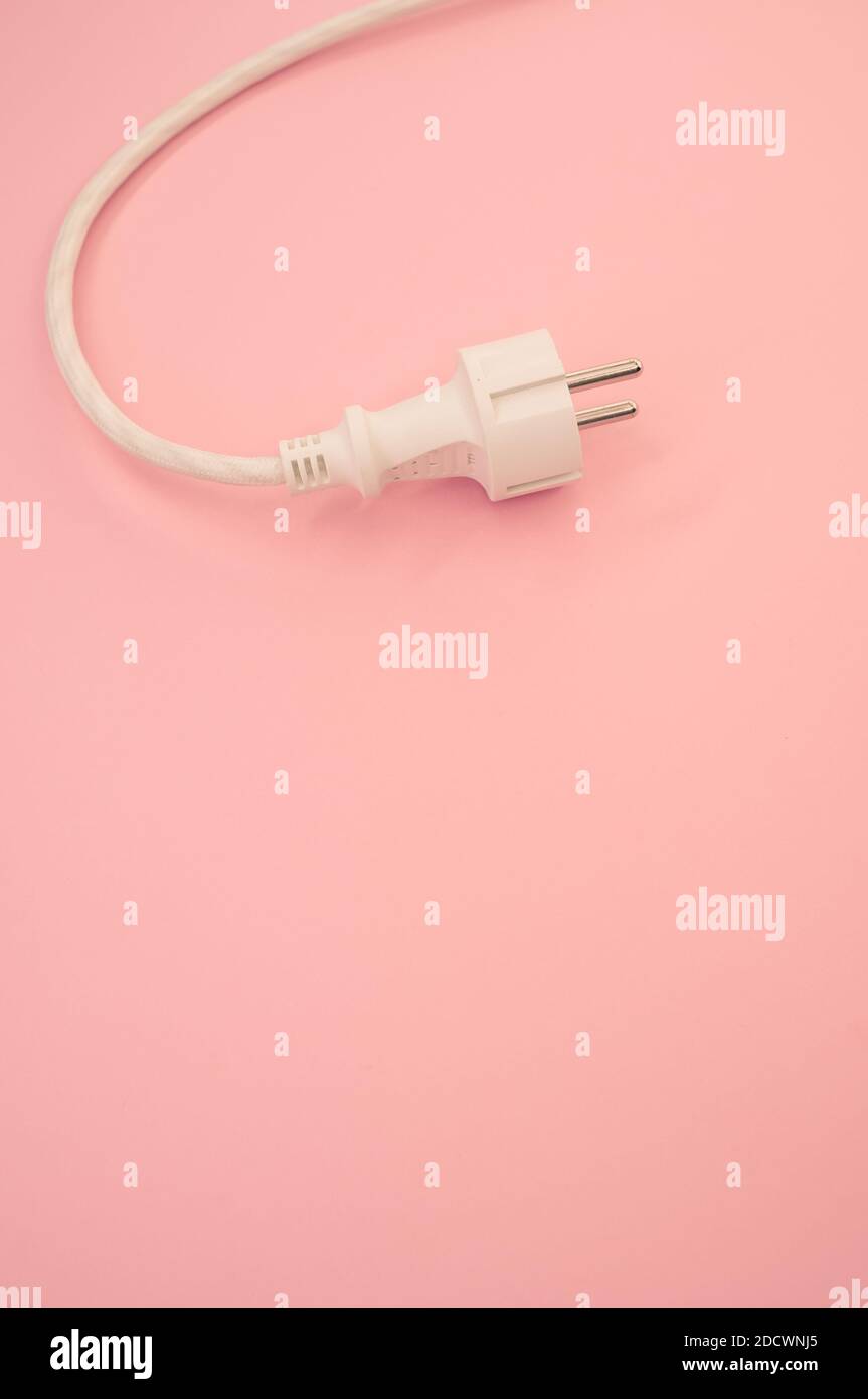 A vertical shot of an electrical wire and plug on a pink surface Stock ...