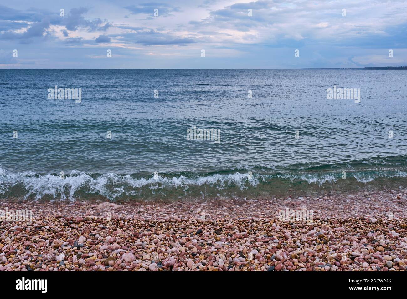 Beautiful seascape. A pebble beach without people with an incoming wave ...
