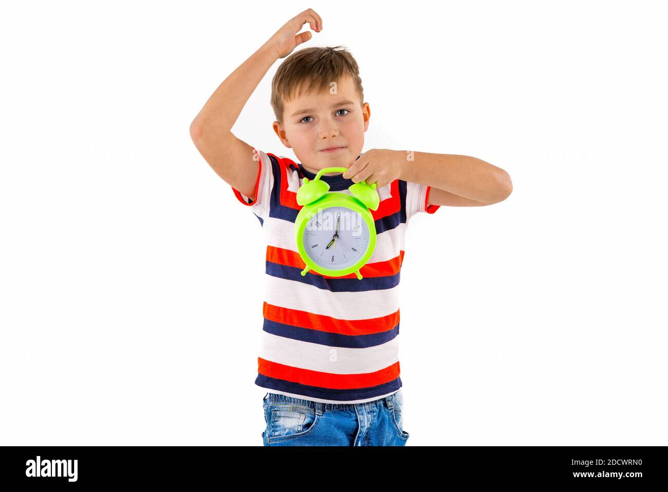 Attractive cute boy holding alarm clock on white isolated studio ...