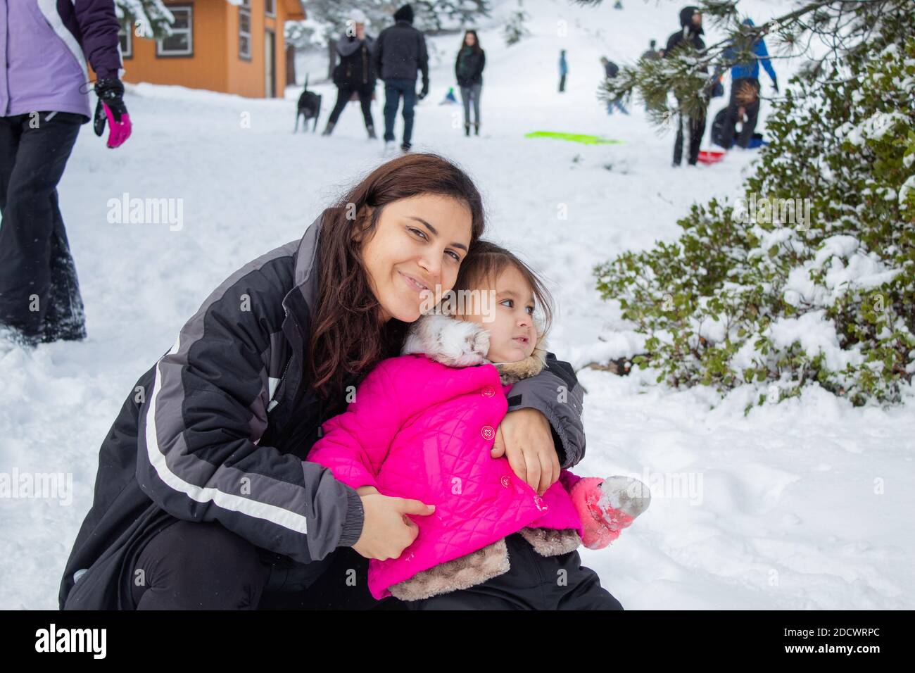 Happy mother and daughter smiling in a snowy forest Stock Photo - Alamy
