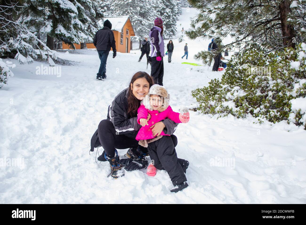 Happy mother and daughter smiling in a snowy forest Stock Photo - Alamy