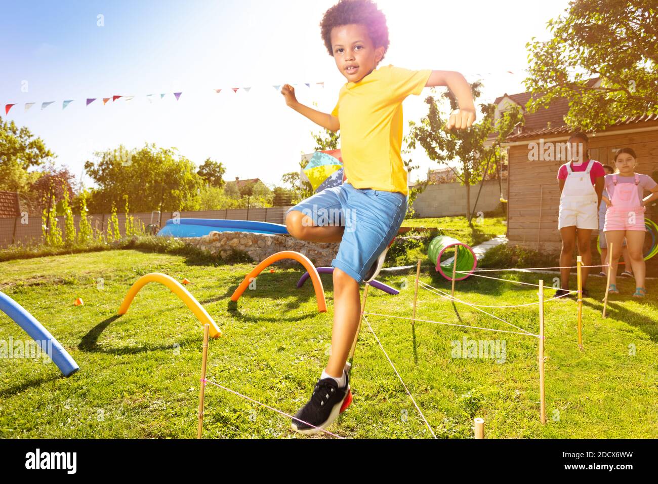 Happy boy jumps in over strings in sequence of obstacles game on ...