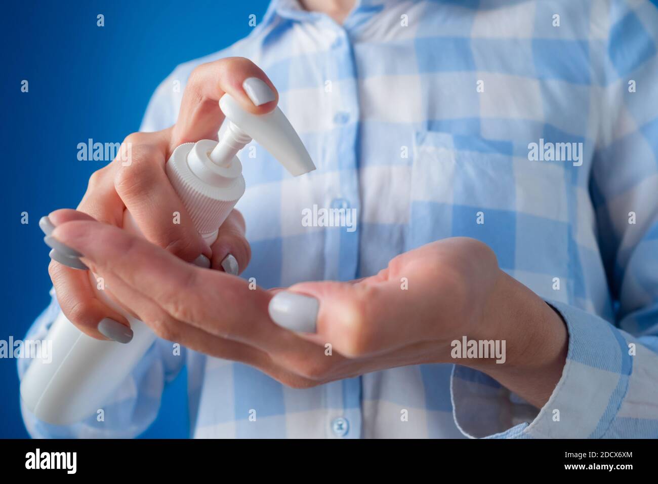 Woman hands squeezing out antiseptic gel on palm - close up front view ...