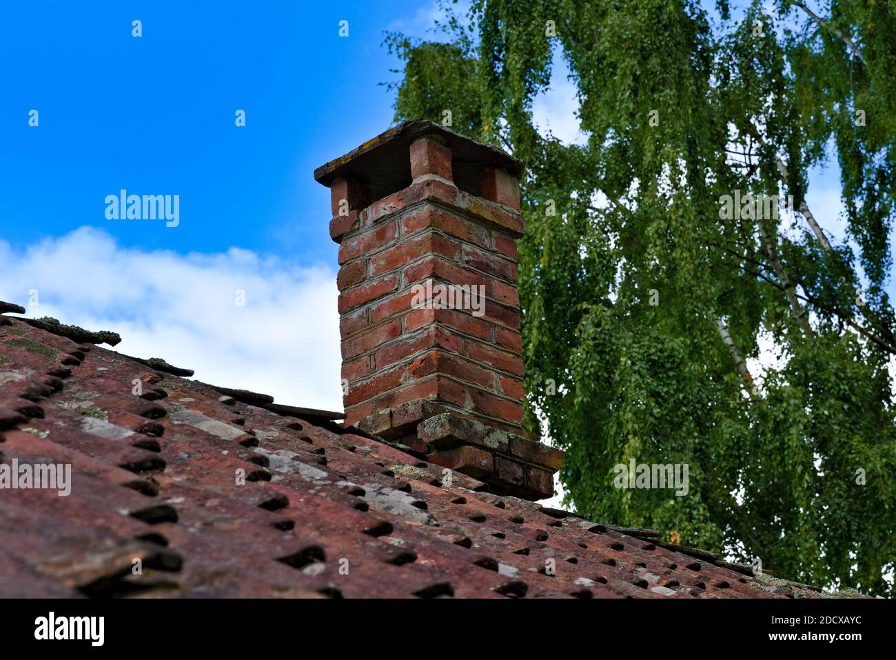 Classic old brick chimney looking weathered and old. Sitting on a roof ...