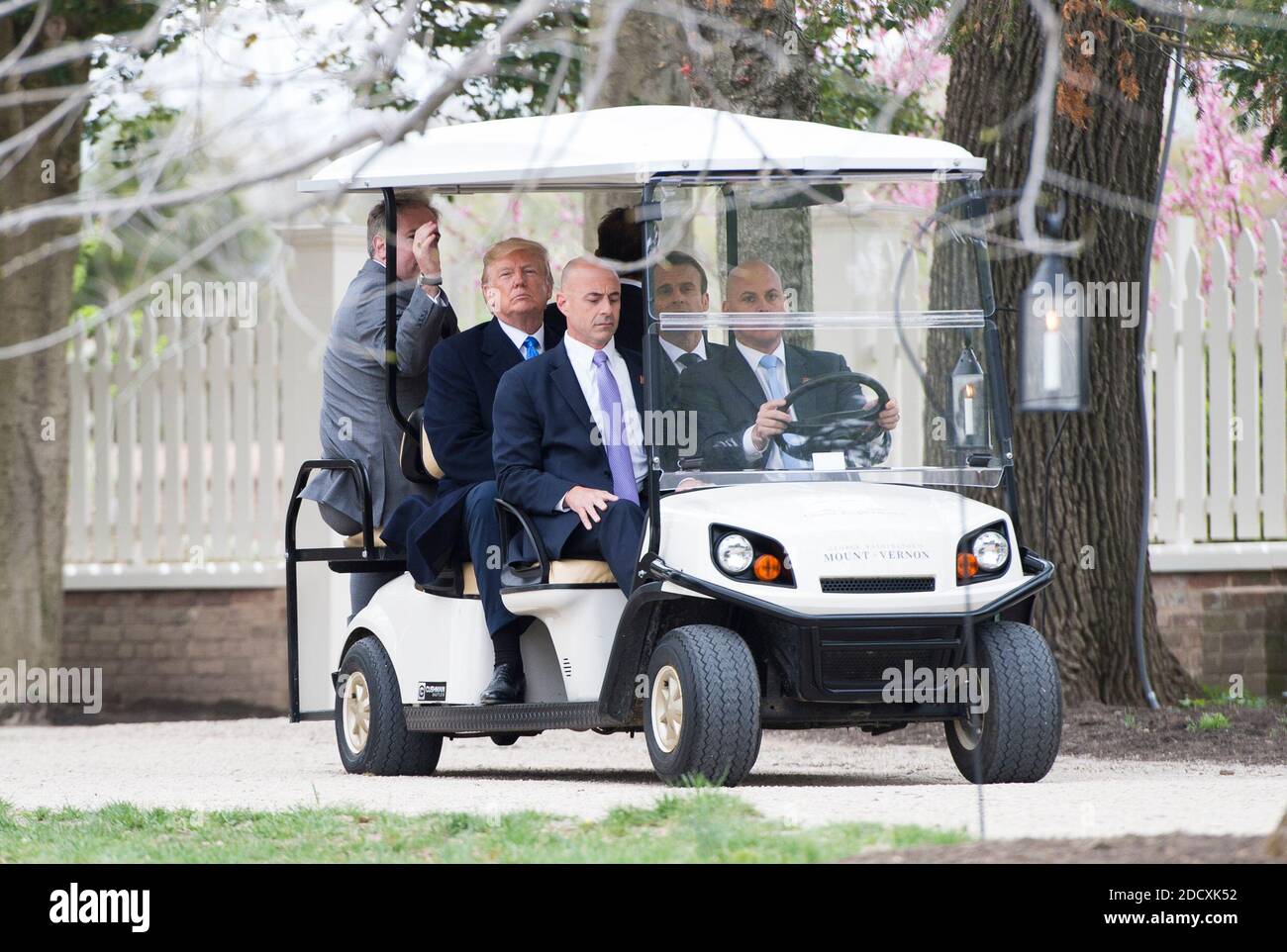 US President Donald Trump and French President Emmanuel Macron ride in ...
