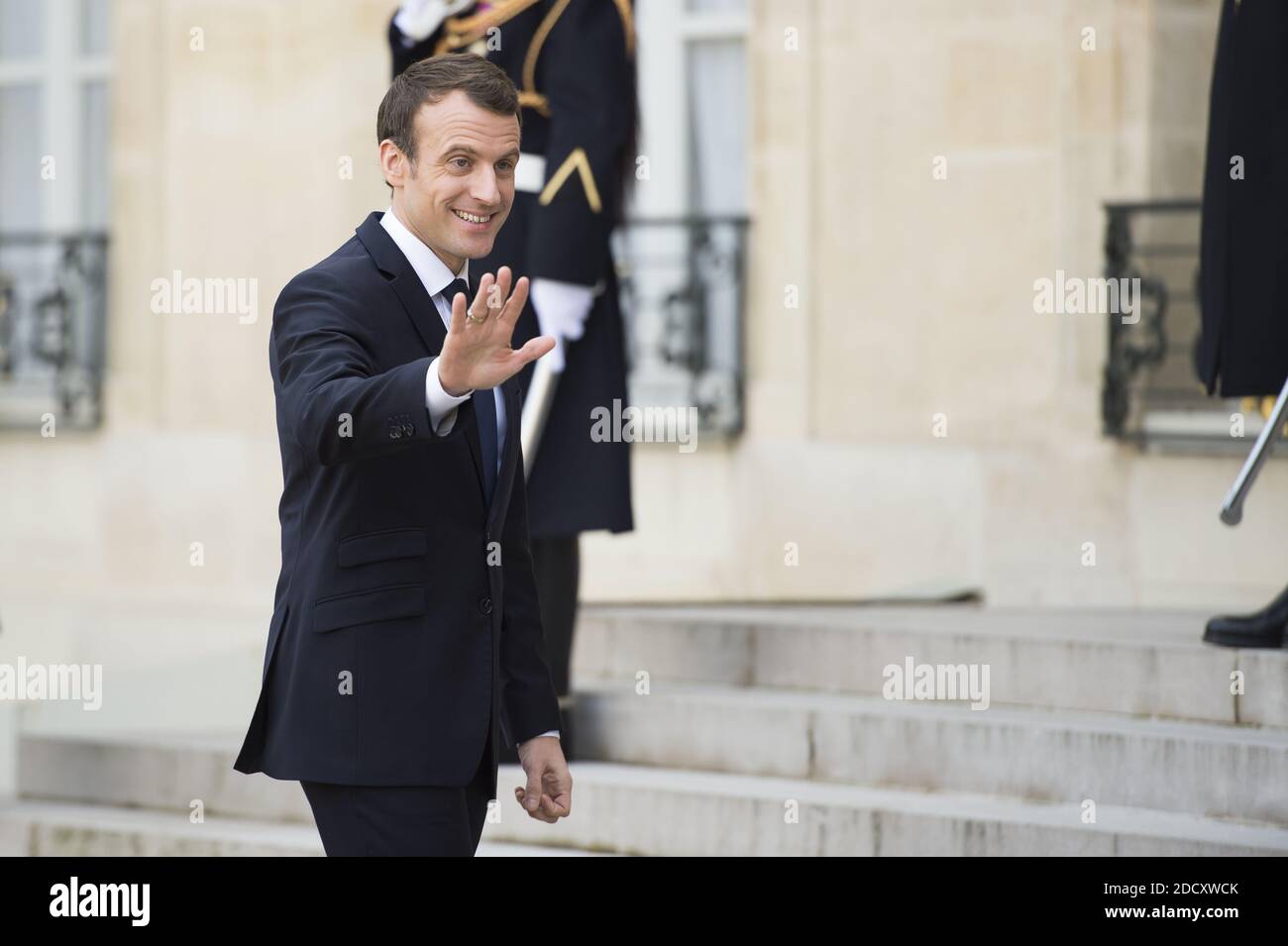 French President Emmanuel Macron smiles and gestures at Elysee Palace ...