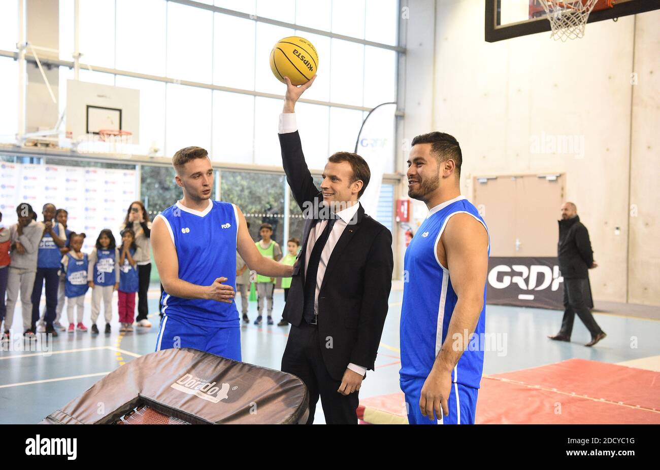 French President Emmanuel Macron watches children practise basketball ...