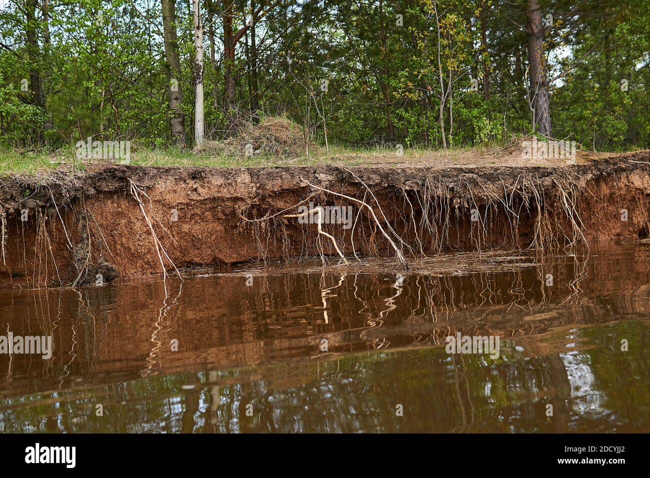 clay bank of the river is destroyed by water during floods Stock Photo ...