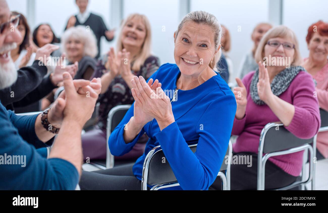 a group of elderly people are sitting in a circle clapping their Stock ...
