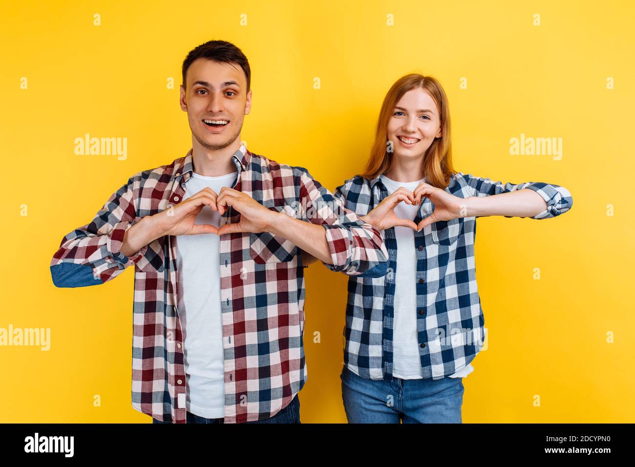 Happy couple, man and woman, show heart with two hands, sign of love ...