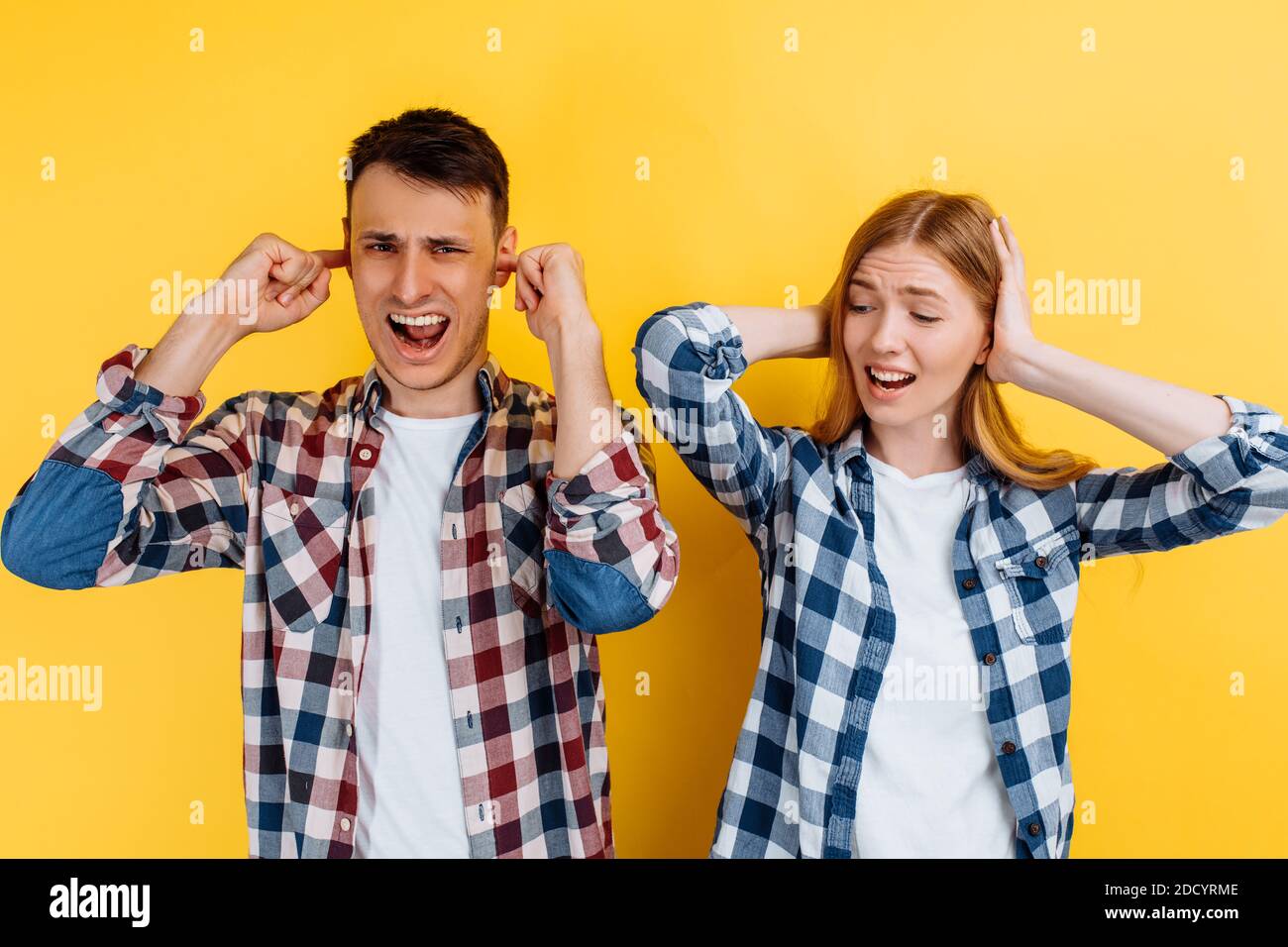 Portrait of young people, man and woman covering ears with hands on ...