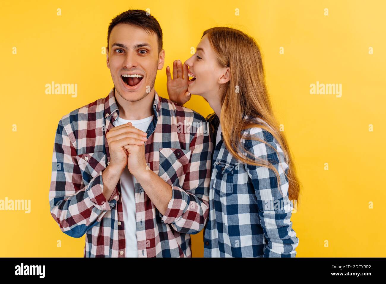 young people, man and woman, woman whispering a secret in the ear of a ...