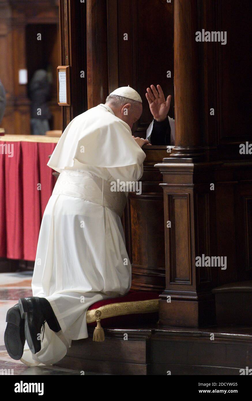 Pope Francis kneels in confession after the celebration of a ...