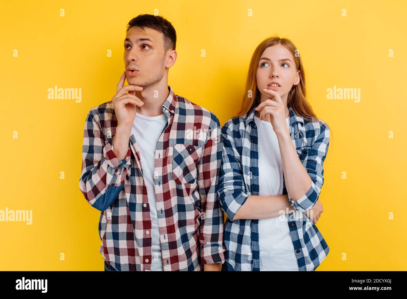 pensive couple, man and woman, putting hand on chin, thinking on yellow ...