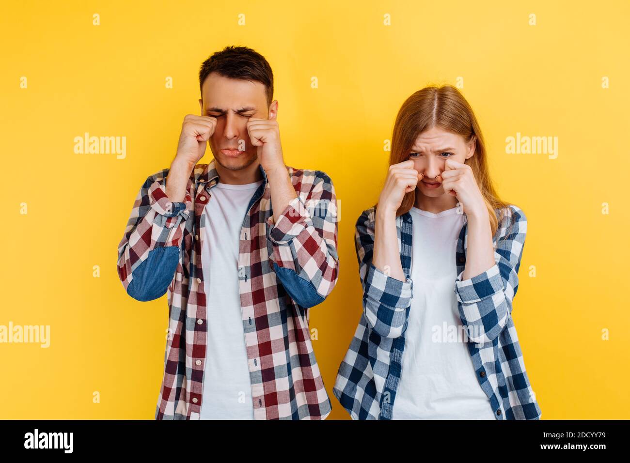 Young unhappy couple crying and looking at camera man and woman on ...