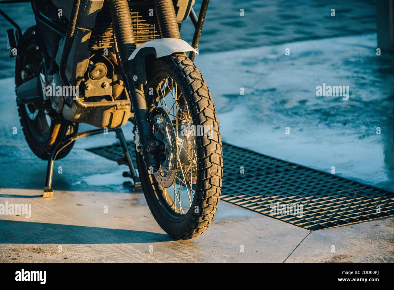Motorbike washing series. Washing a motorcycle at a car wash at sunset ...